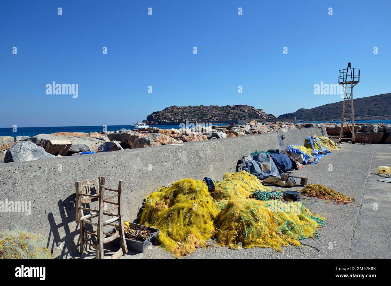 Greece, Crete, mole with fishing nets and boats in the port of Plaka ...