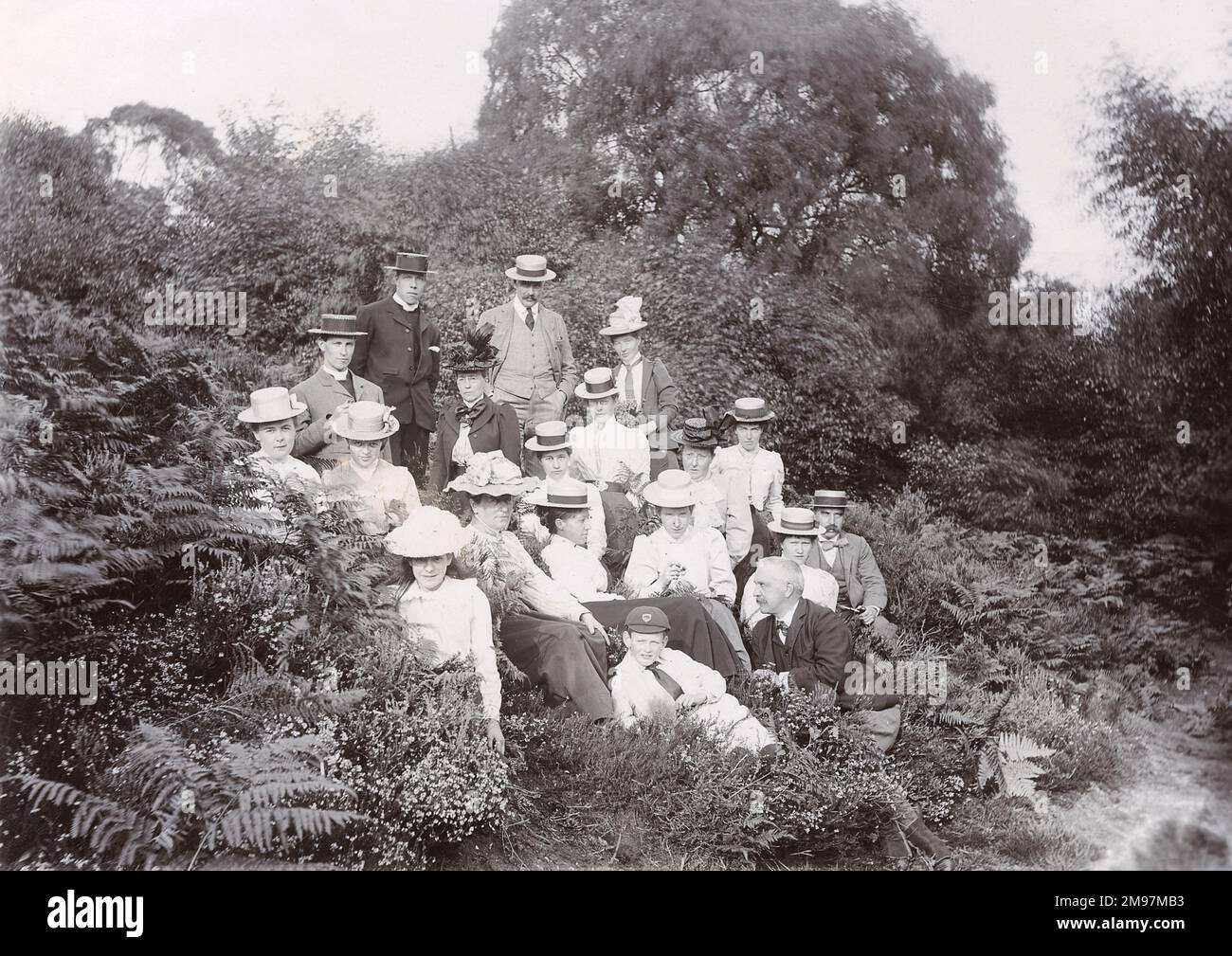 Group of people, including two clergymen, relaxing in the countryside ...