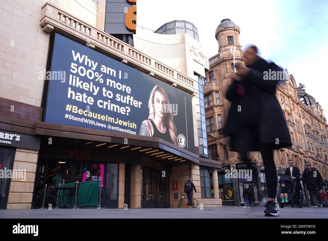 People walk past a billboard in Leicester Square, London, which is part ...