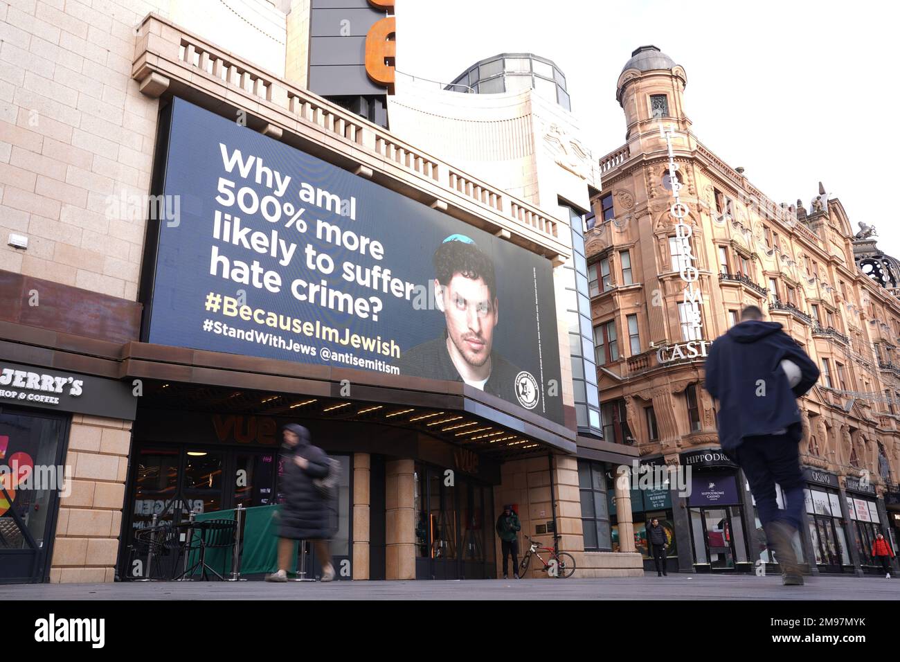 People walk past a billboard in Leicester Square, London, which is part ...