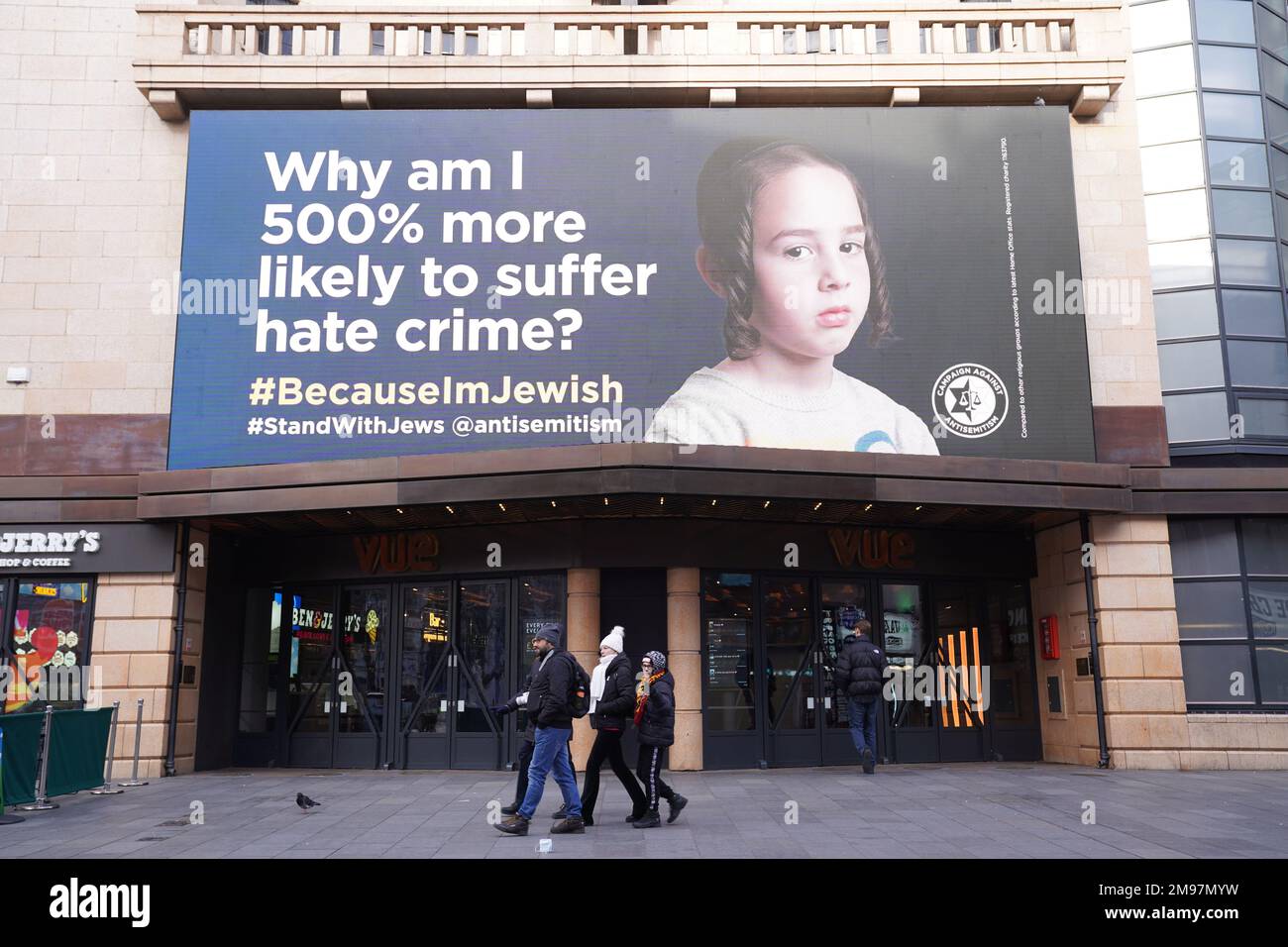 People walk past a billboard in Leicester Square, London, which is part ...