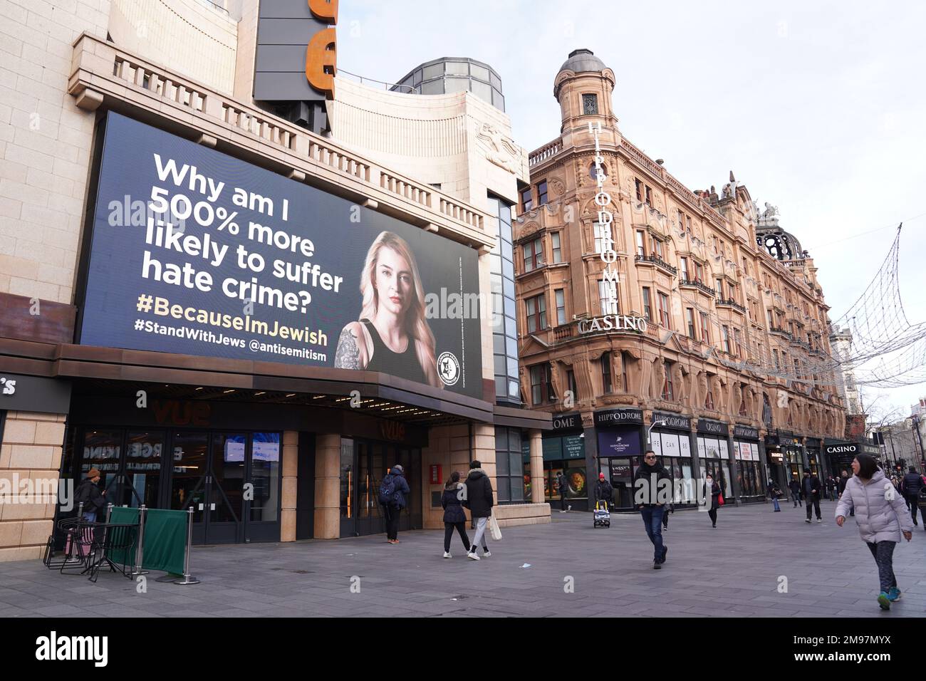 People walk past a billboard in Leicester Square, London, which is part ...