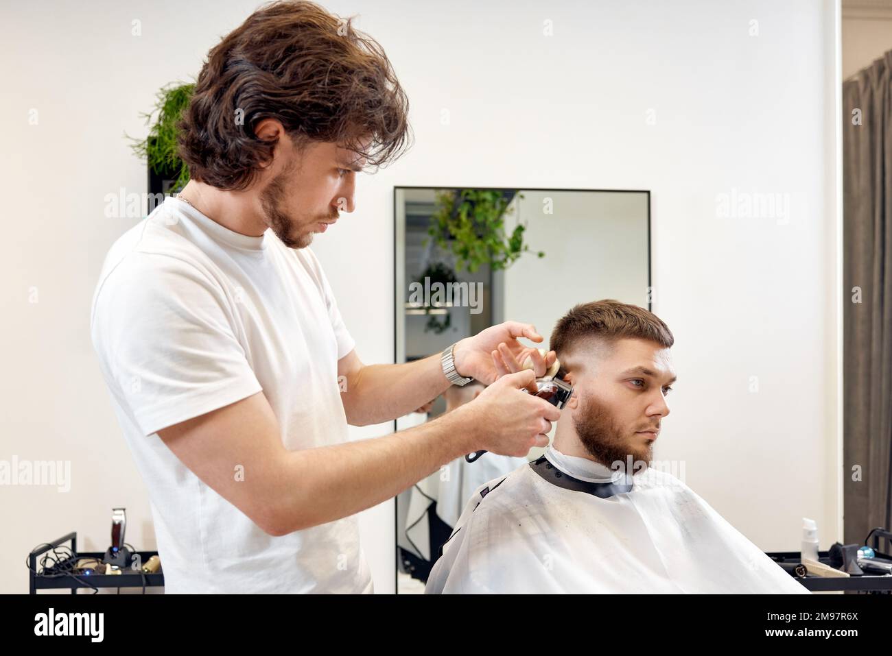 Barber making hairstyle confident hi-res stock photography and images ...
