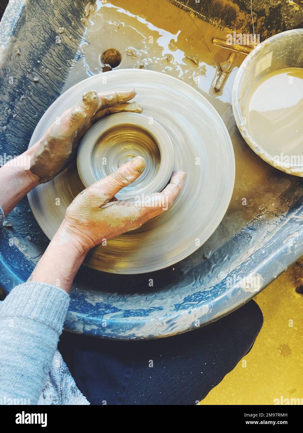 Overhead view of a woman moulding clay on a potter's wheel Stock Photo ...