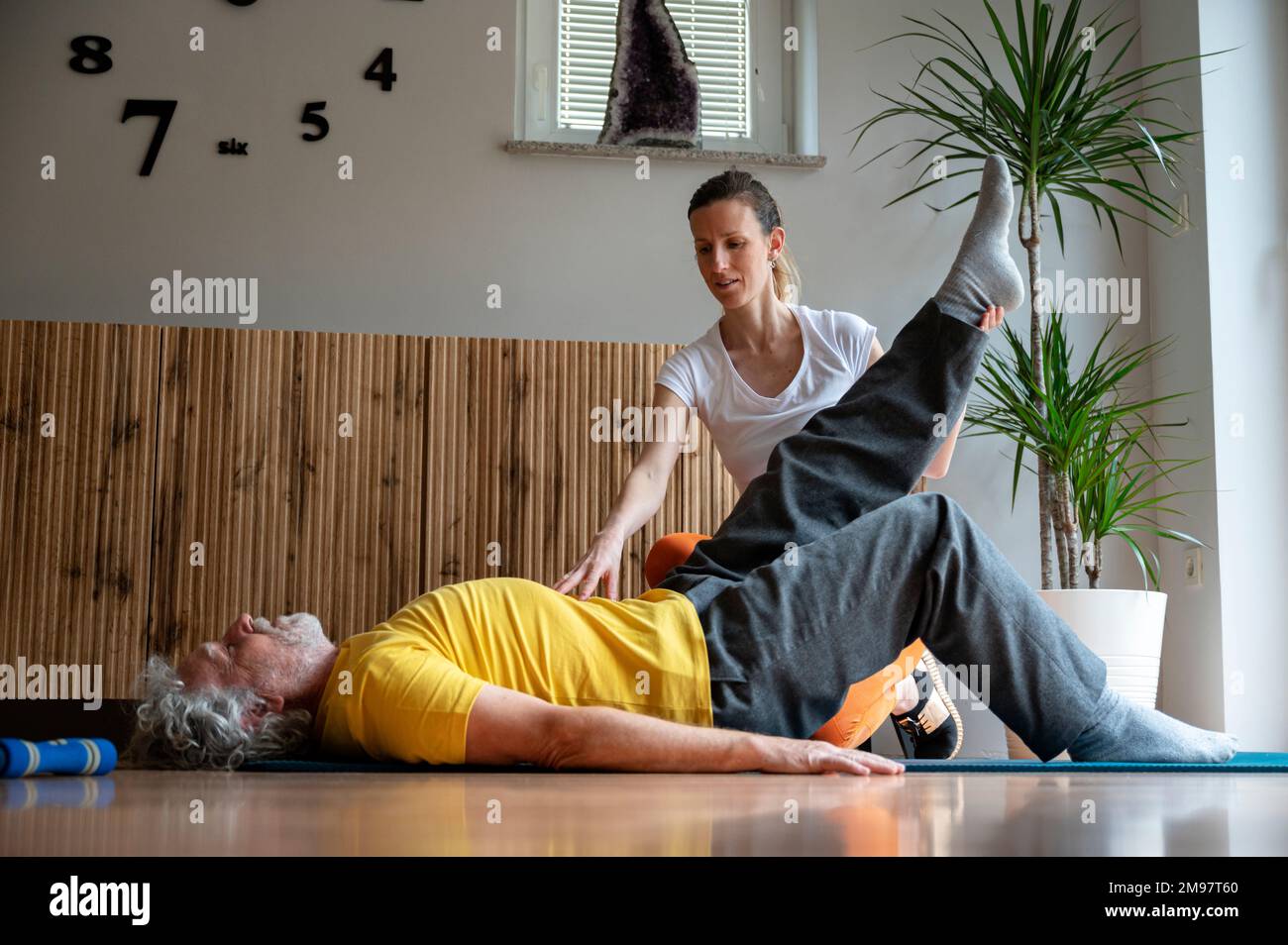Young physiotherapist working with a senior man to teach him the right ...