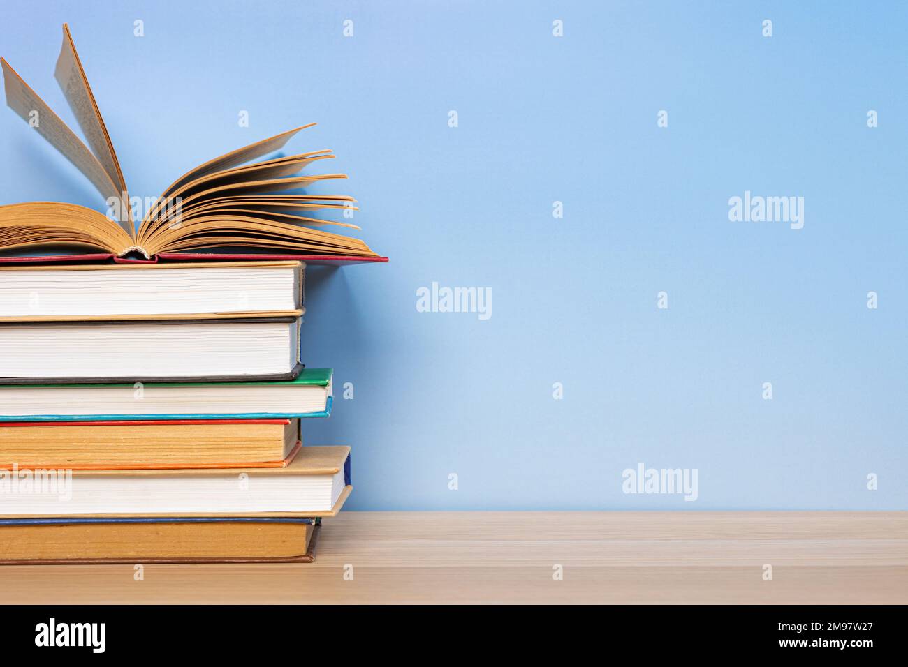 Stack of books in the colored cover lay and open book whith old pages ...