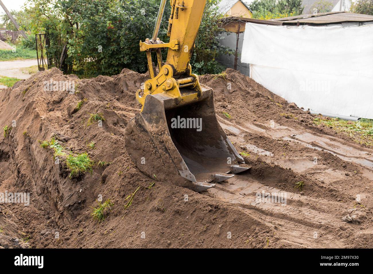 The excavator's bucket stands on the ground in an industrial zone ...