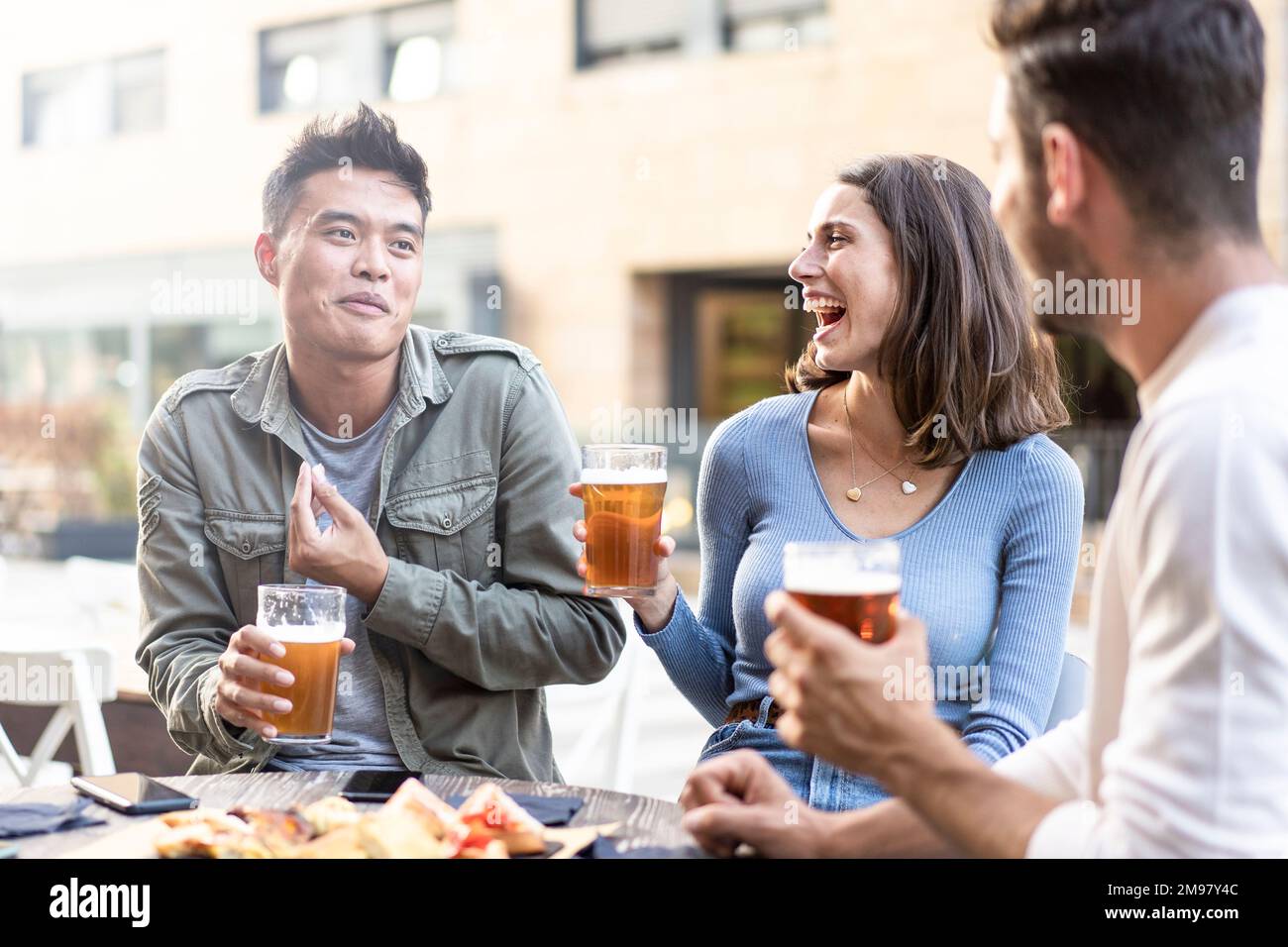Multiracial friends drinking beer at brewery pub garden - Genuine ...