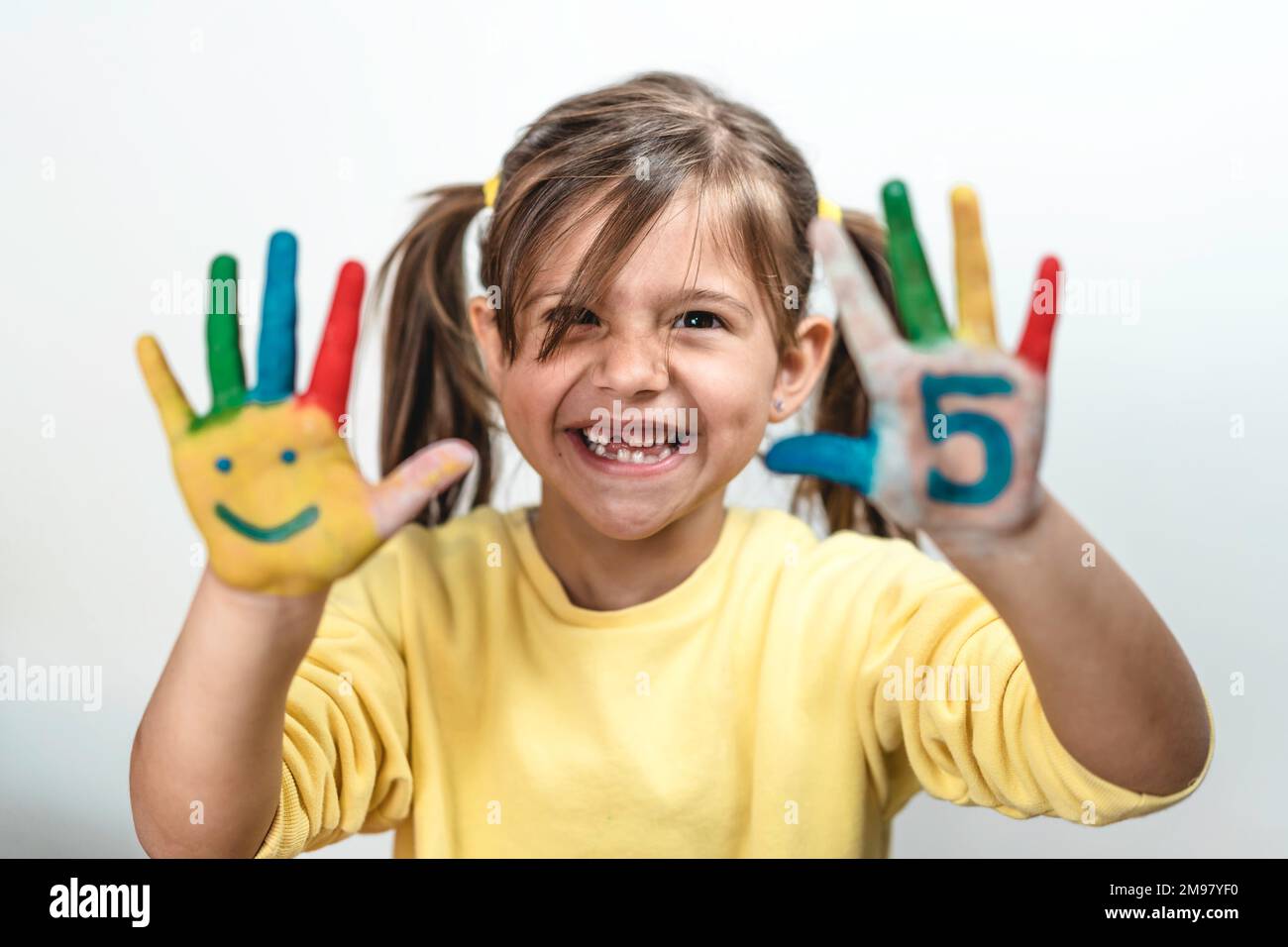 Happy toothless little girl with the five number painted on the hand ...