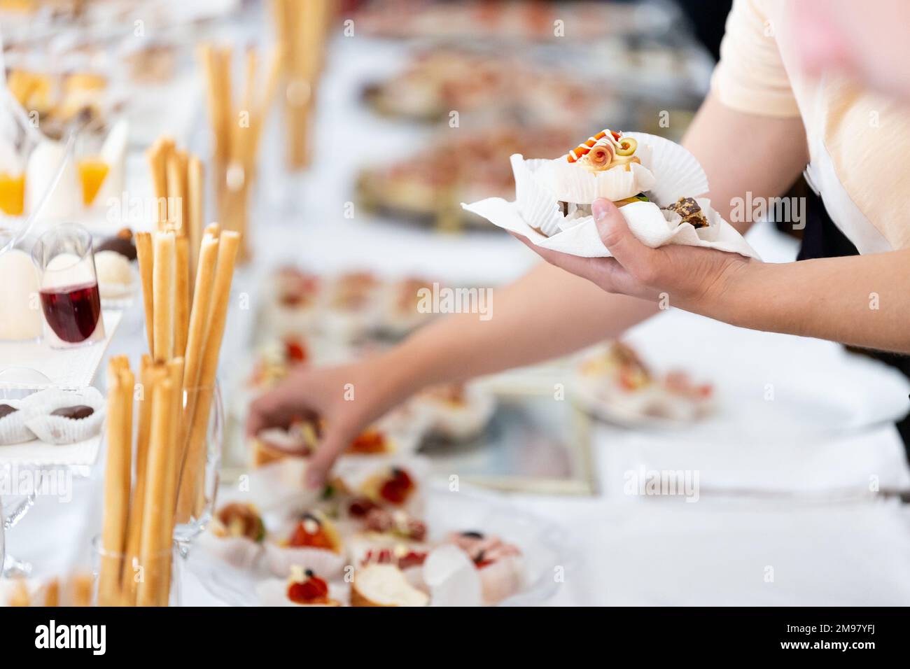 Close up of people serving themselves with canapes in restaurant ...