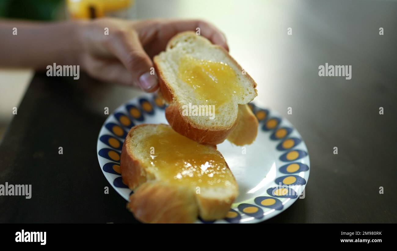 Hand putting jelly on bread close-up Stock Photo - Alamy