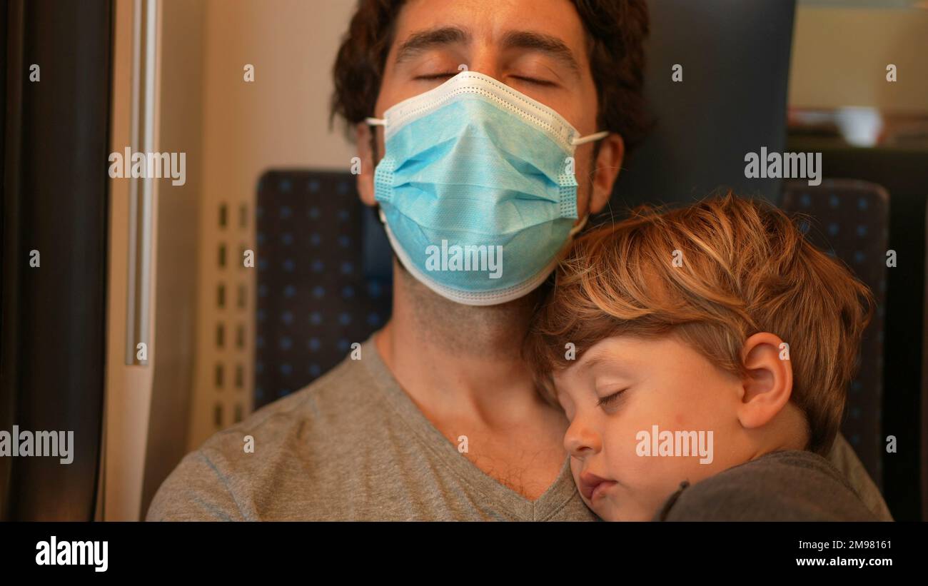 Father and toddler son sleeping on train wearing covid face mask Stock ...