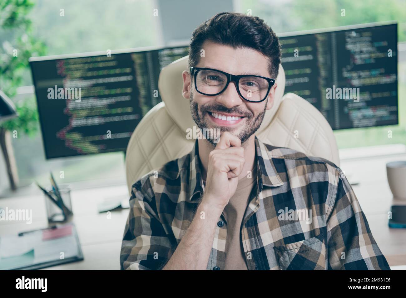 Photo of smart clever coder dressed eyewear hand arm chin working modern gadget indoors ...