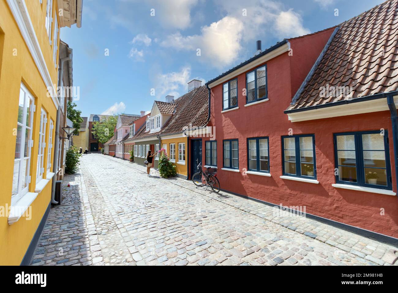 The cloudy blue sky over the street and buildings in Odense, Denmark ...