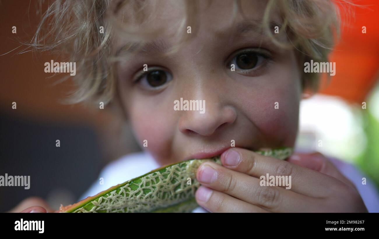 Hungry kid eating fruit, child eats melon. Little boy eating healthy ...