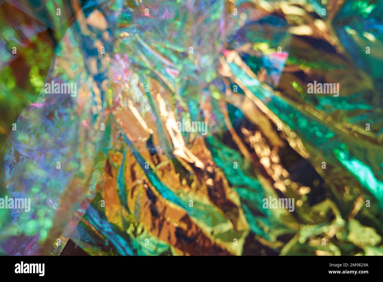 Unfocused holographic colors of mother-of-pearl foil. Crumpled ...