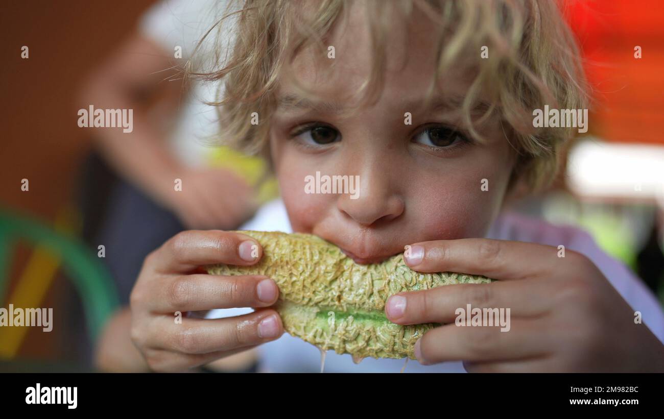 Hungry kid eating fruit, child eats melon. Little boy eating healthy ...