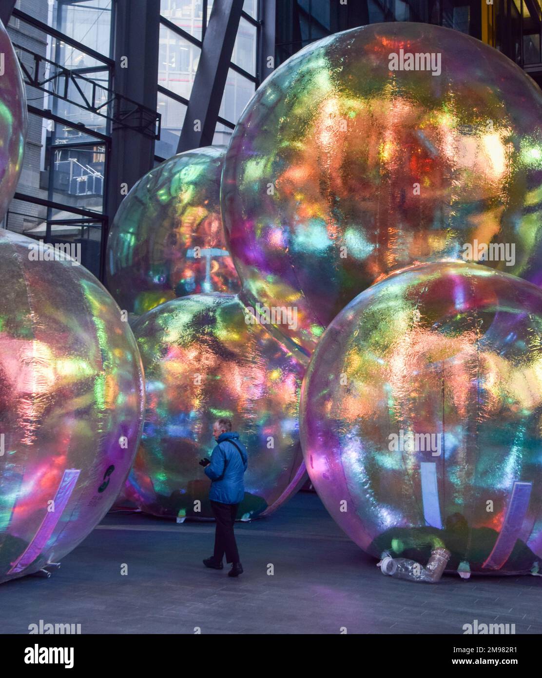 London, UK. 17th January 2023. A visitor admires the giant iridescent ...