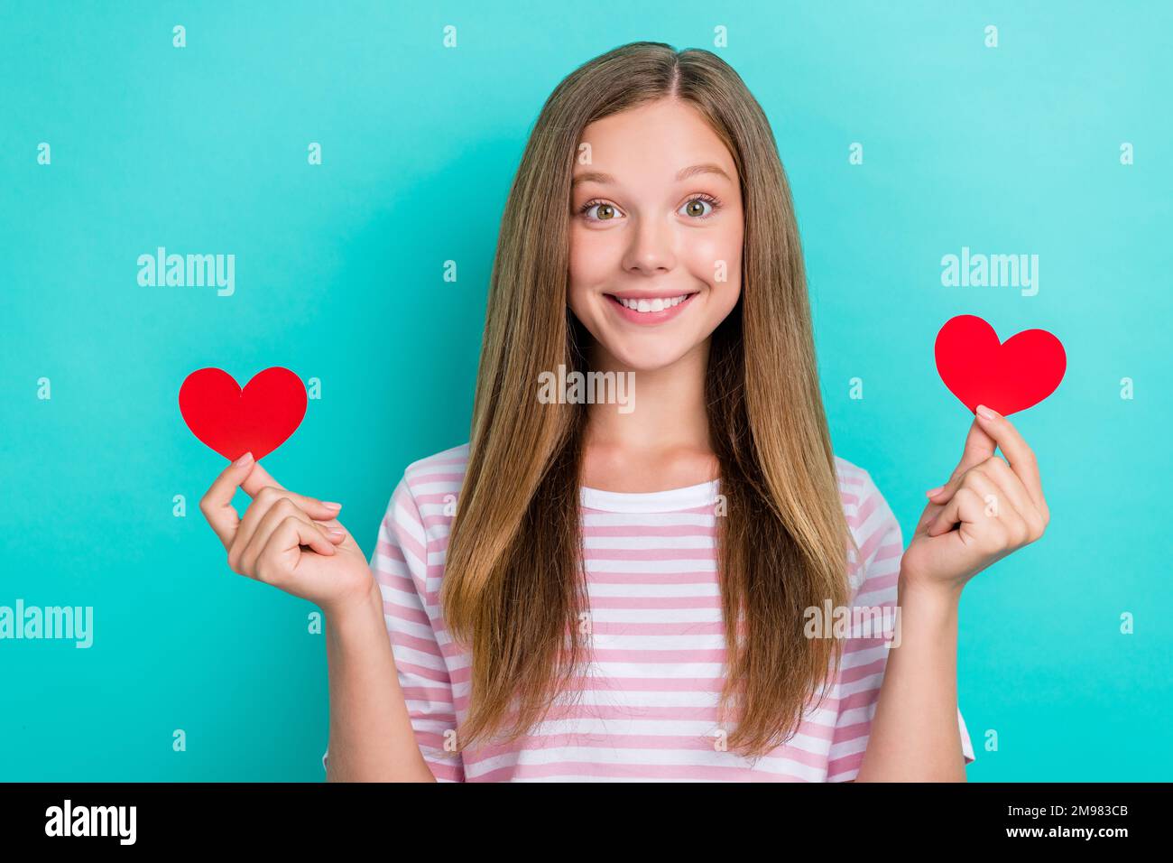 Photo of pretty cute lady wear striped t-shirt rising two red hearts ...