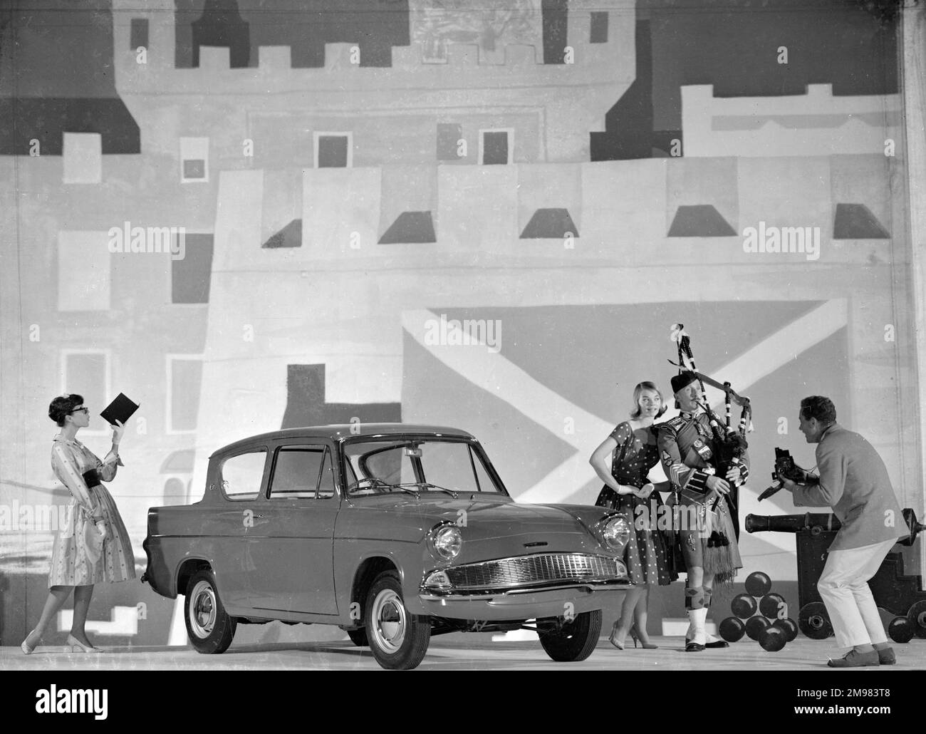 Advertisement for Ford Anglia cars -- male and female models posing ...