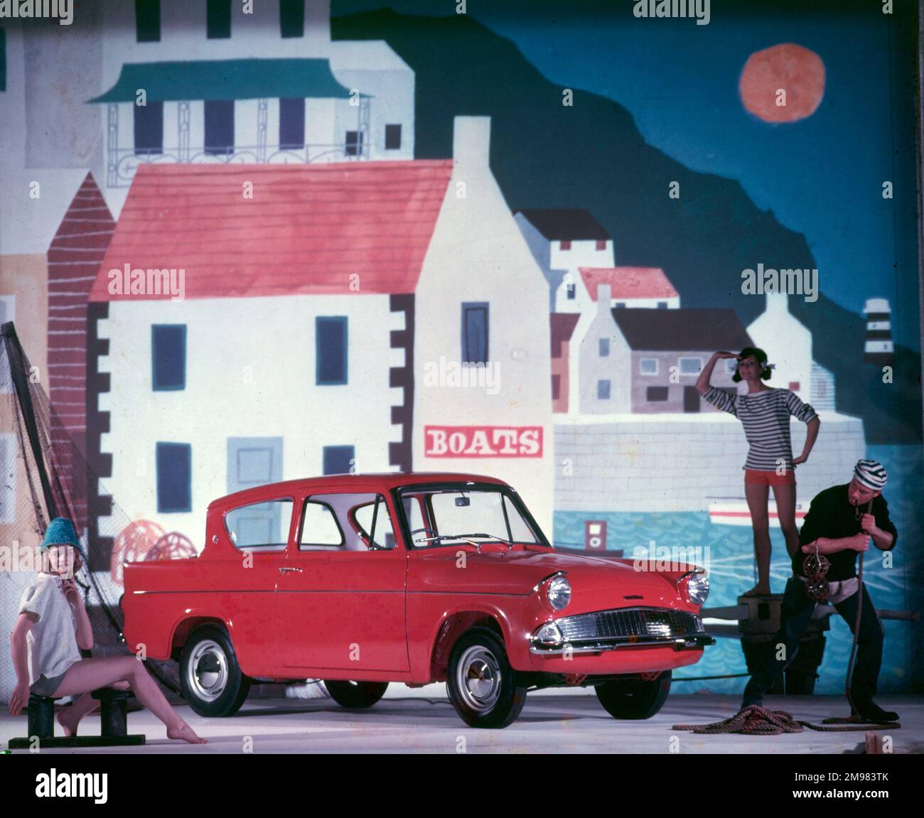 Advertisement for Ford Anglia cars -- male and female models posing ...