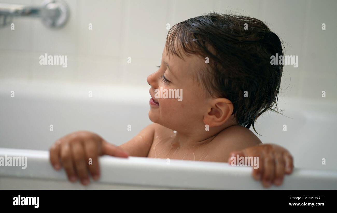 Children taking bath splashing water. Two little boys taking bath ...