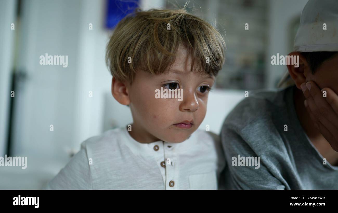 Children watching movie staring at screen sitting at couch. Kids ...
