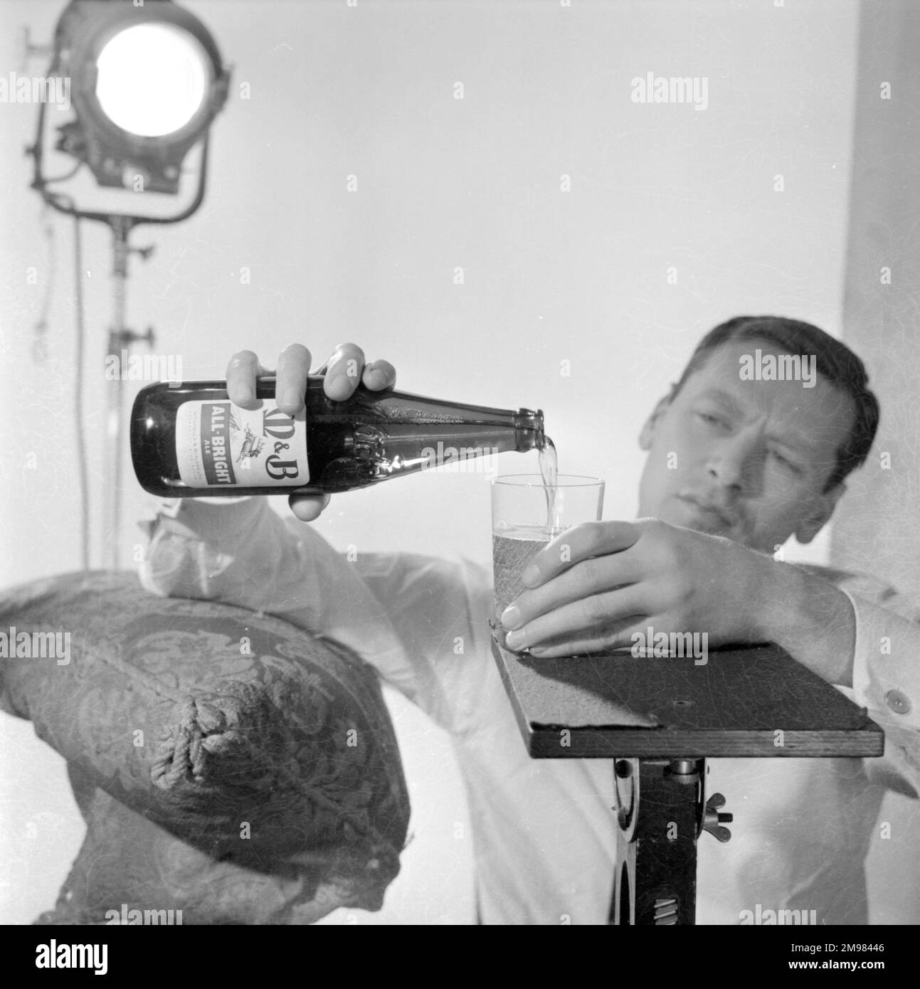 Advertisement for M&B All Bright beer -- male model pouring beer from a ...