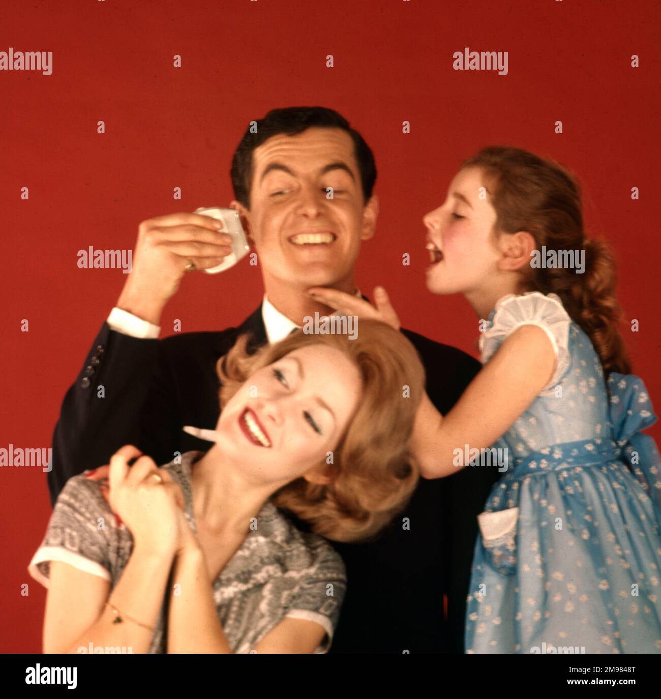 Advertisement for Remington shavers -- three models posing as a happy ...