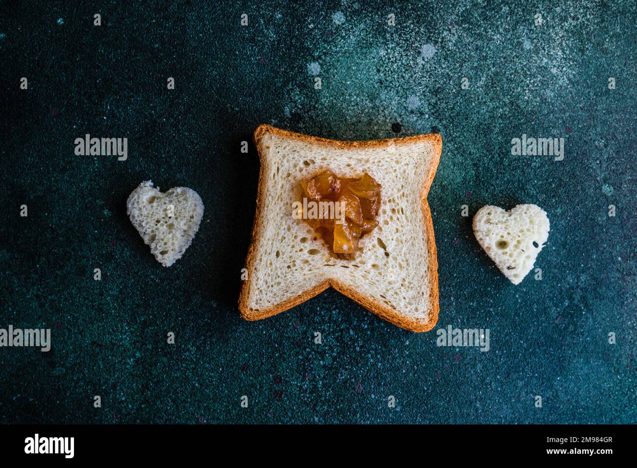 Overhead view of a slice of toast with heart shape cut out filled with ...