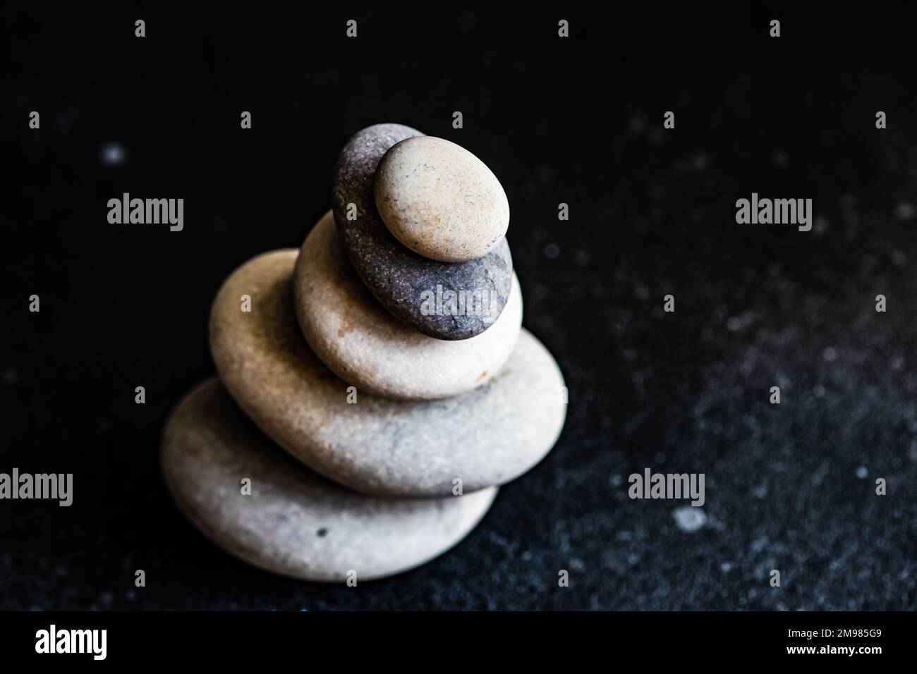 Overhead view of a stack of pebbles against a black background Stock ...