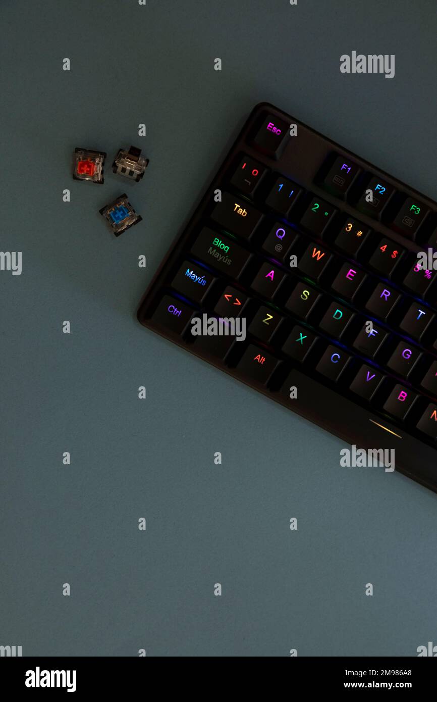 Vertical image of a gamer keyboard on a gray base with switches on the ...