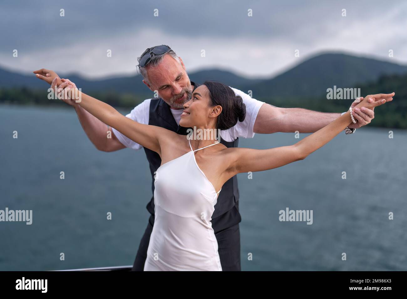 Romantic couple in love have fun sailing in the sea standing on yacht ...