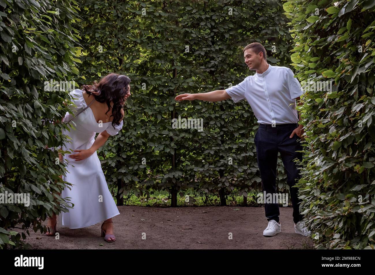 A couple in love has fun in the ornamental garden. Newlyweds in summer ...