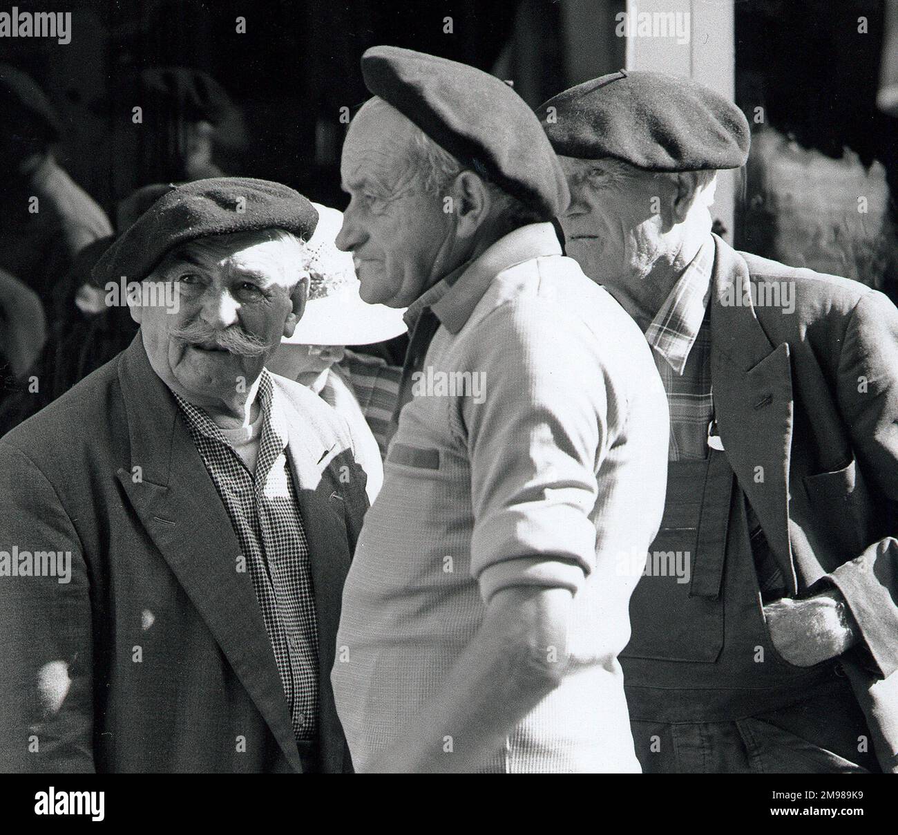 Frenchmen wearing berets at a farmers' market, Sarlat, Dordogne, France ...
