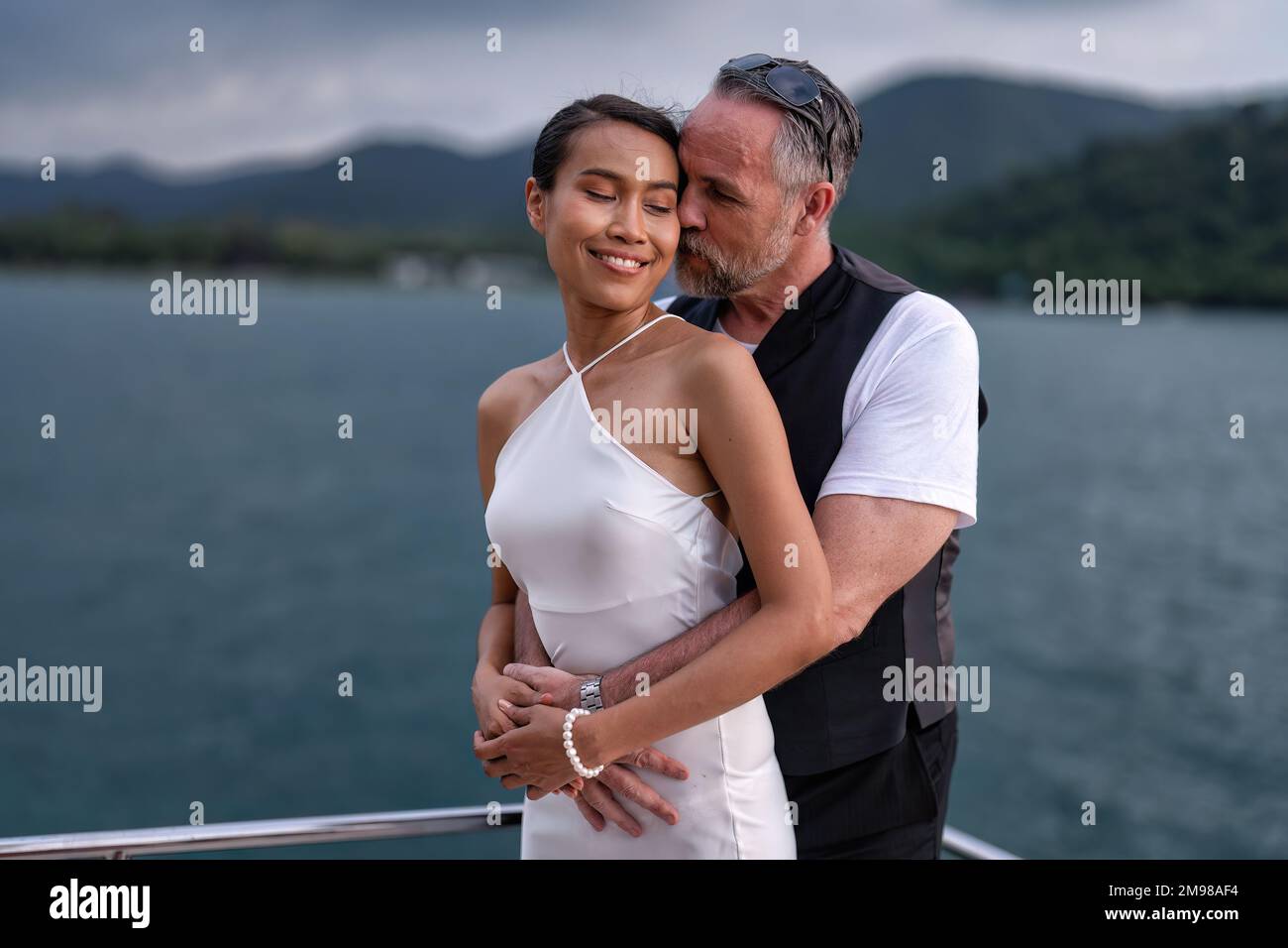 Romantic couple in love have fun sailing in the sea standing on yacht ...