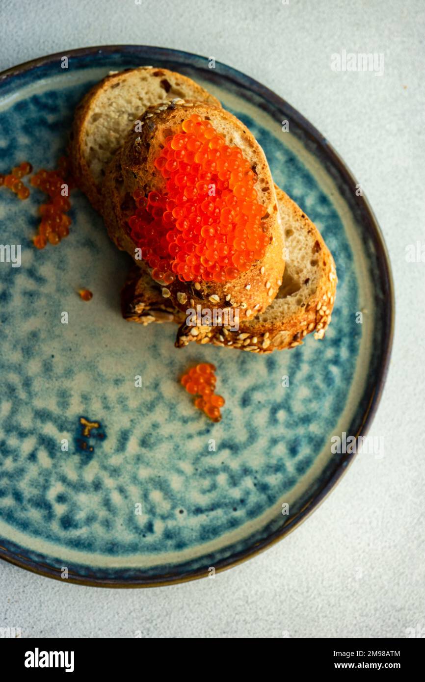 Overhead view of slices of seeded sourdough bread with red caviar on a ...