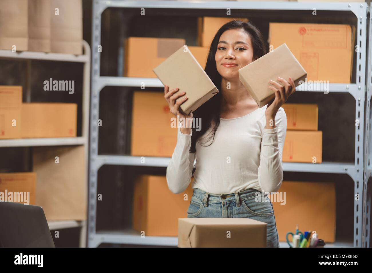 A young woman working at home for packeting parcel boxes to shipping ...