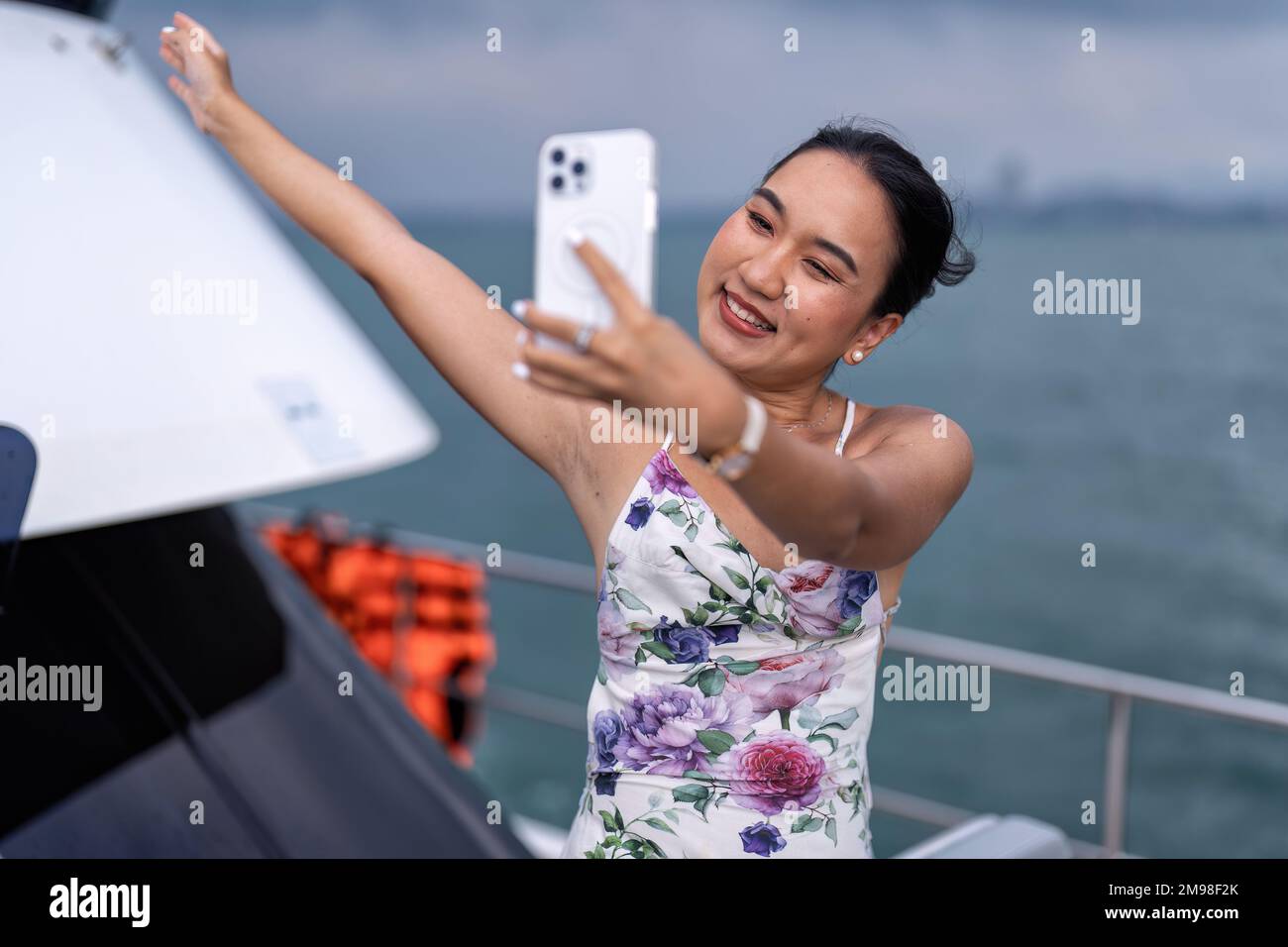 Beautiful girl have fun sailing in the sea sitting on yacht deck enjoy amazing view and selfie ...