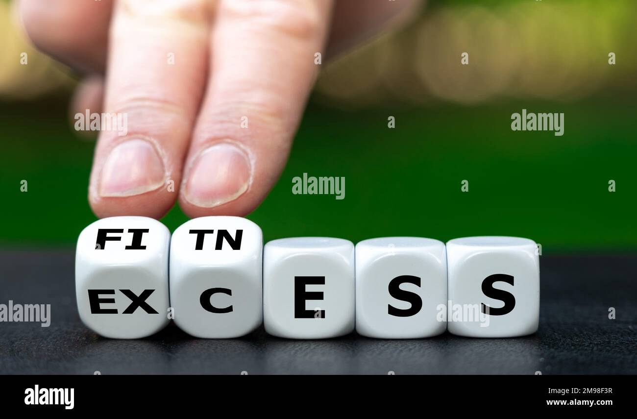 Hand turns dice and changes the word excess to fitness Stock Photo - Alamy