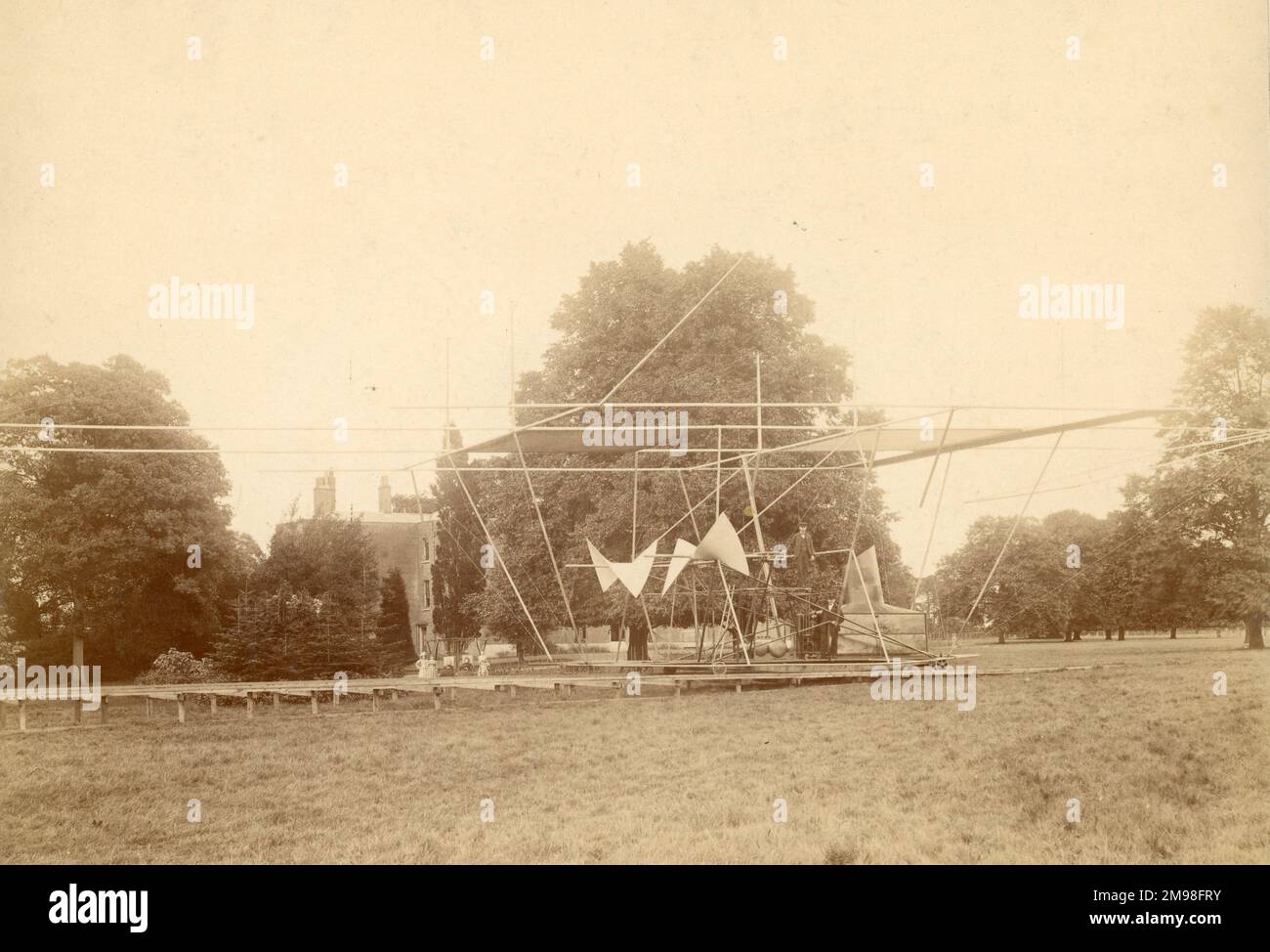 Sir Hiram Maxim operating the valve of the steam engine during a ...