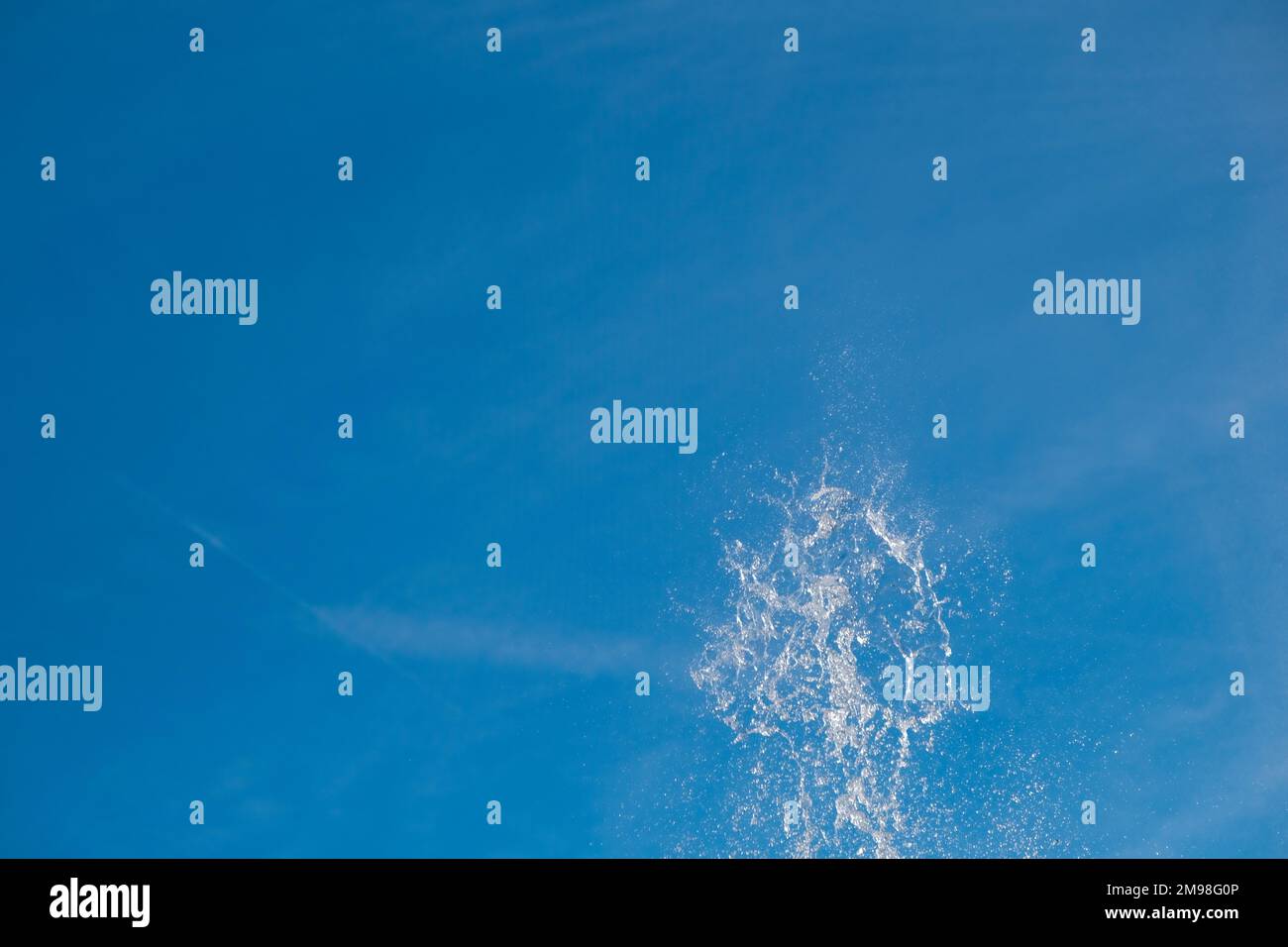 Water jet plashing and sparkling in bright sunny blue shy Stock Photo ...