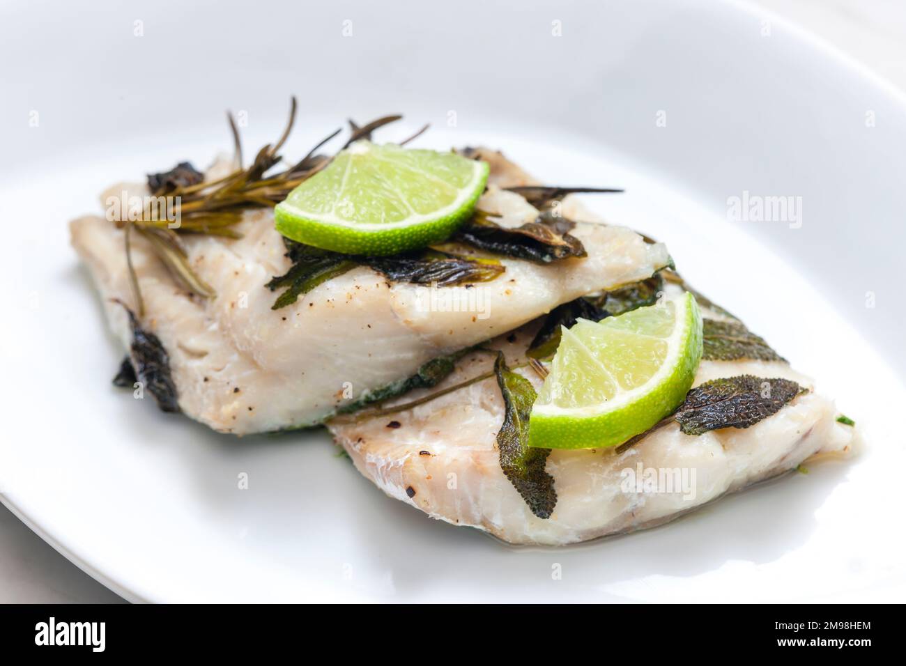 white fish fillet baked with herbs Stock Photo - Alamy