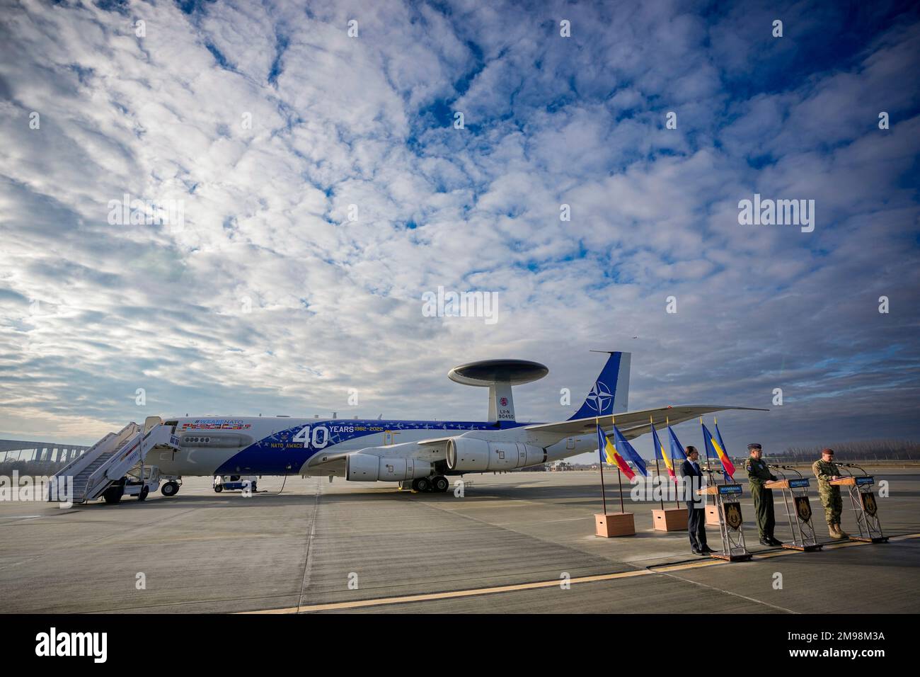 Officials speak backdropped by a NATO AWACS aircraft at the Baza 90 ...