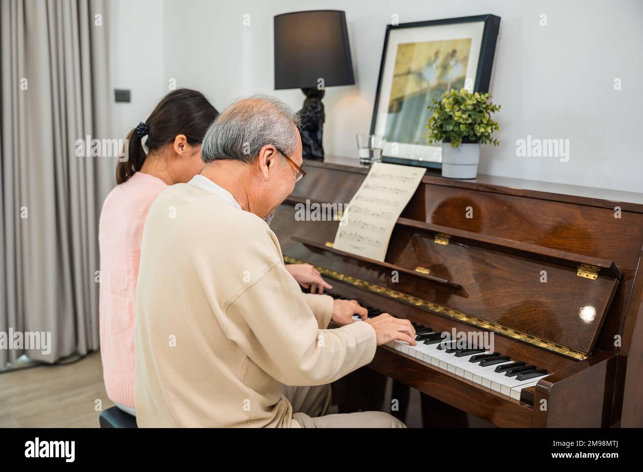 Asian young woman teaching piano for senior man teaching Stock Photo ...
