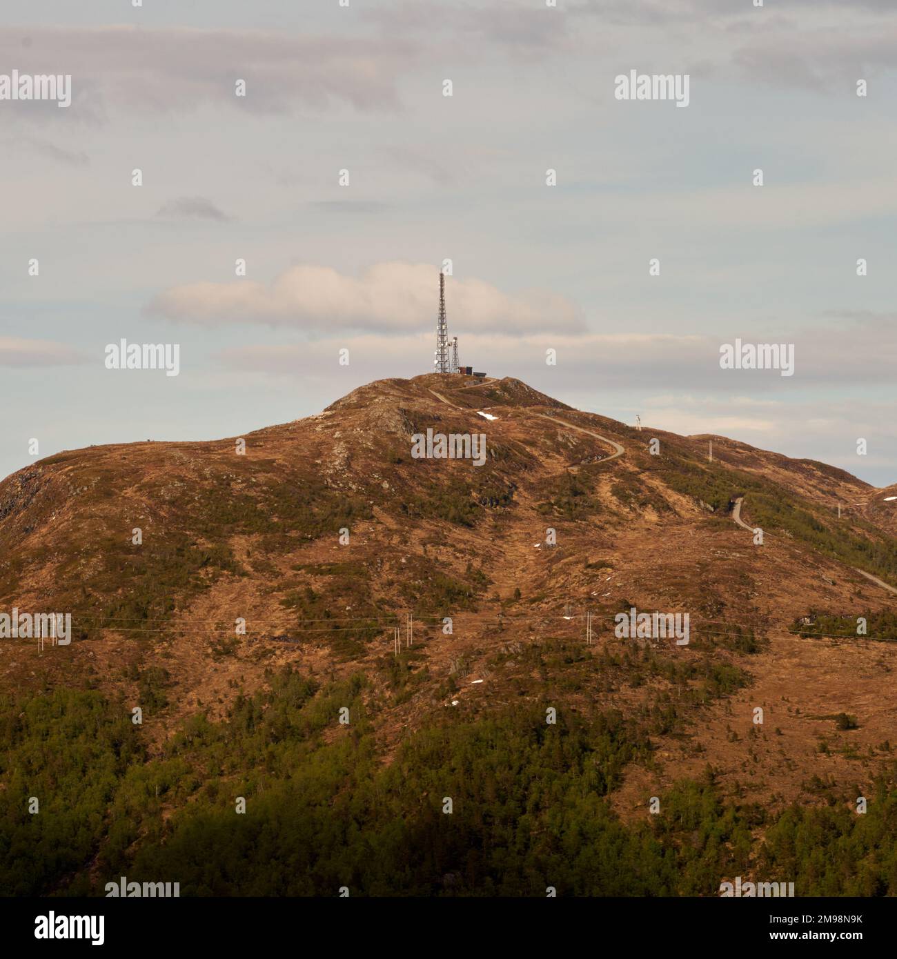An aerial view of a telecommunication tower on top of a brown hill in ...
