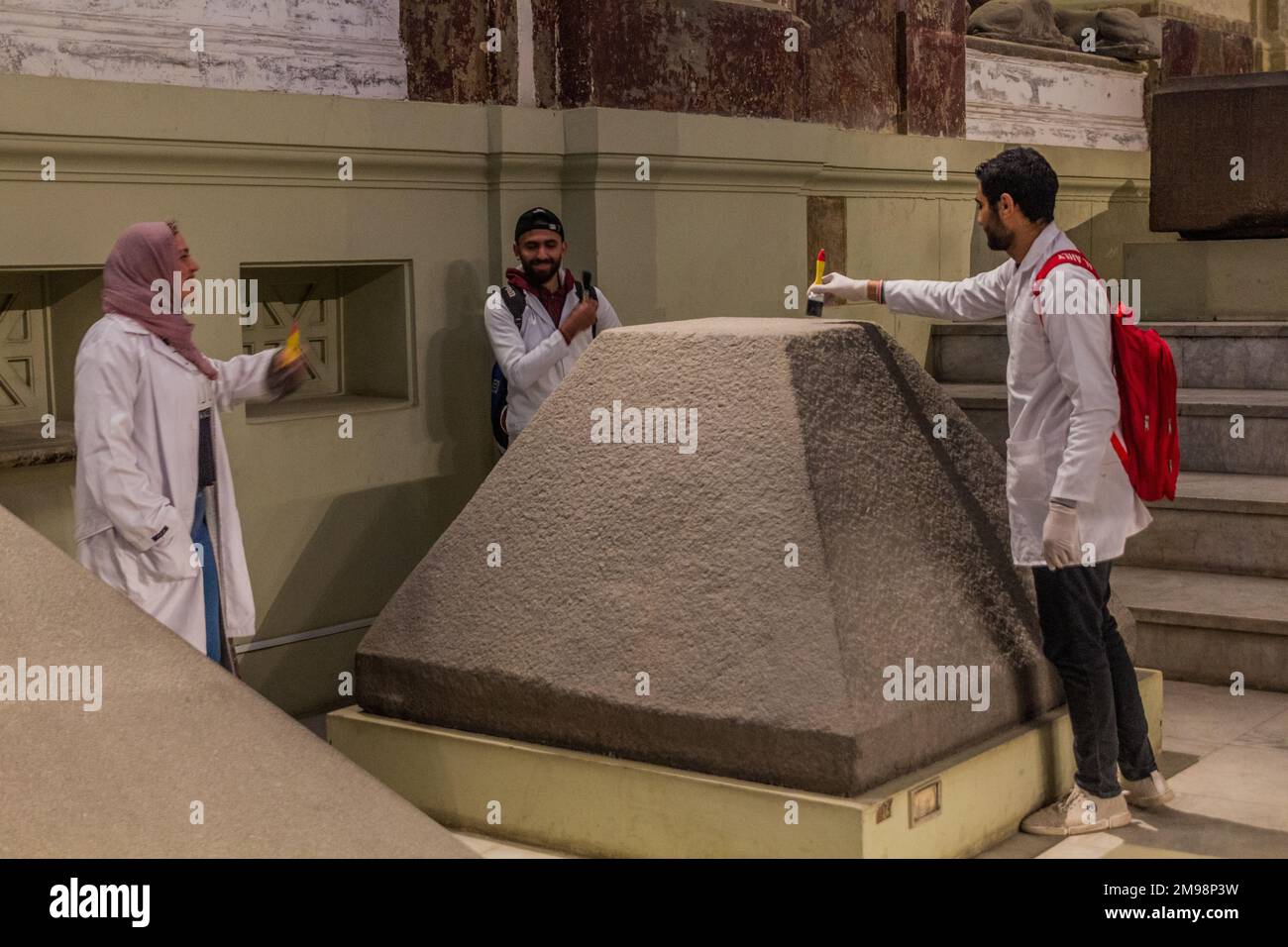 CAIRO, EGYPT - JANUARY 27, 2019: Employees cleaning a pyramidion in the Egyptian Museum in Cairo ...