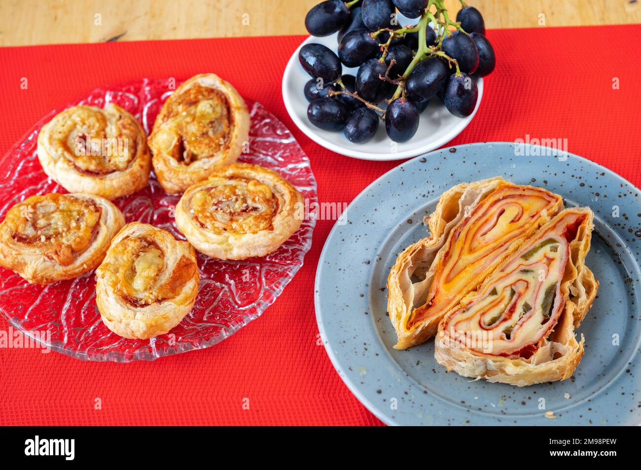 Salty rolled pastry with ham, cheese, jalapenos and sesame seed on two ...
