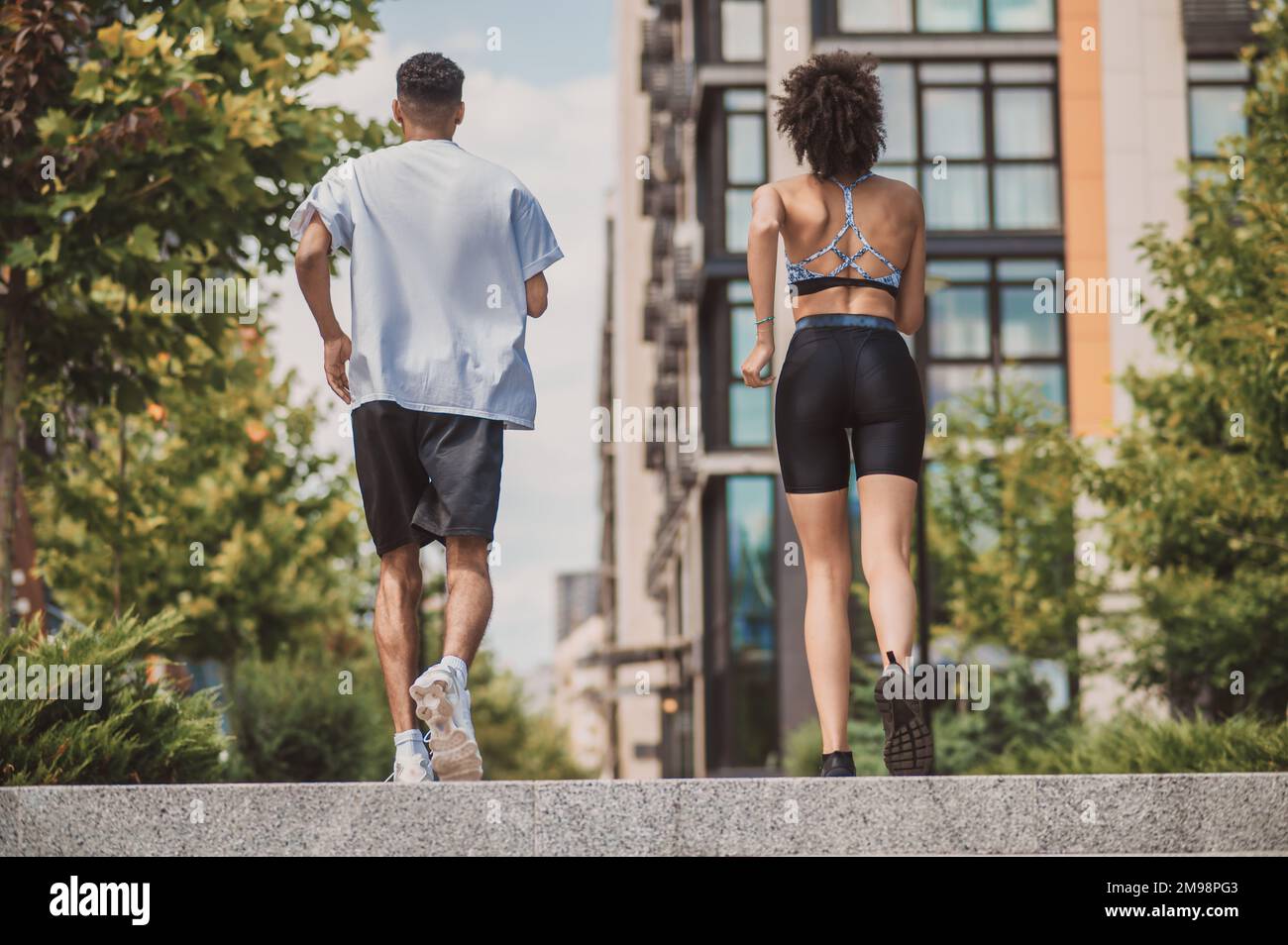 Two adult people working out together outdoors Stock Photo - Alamy