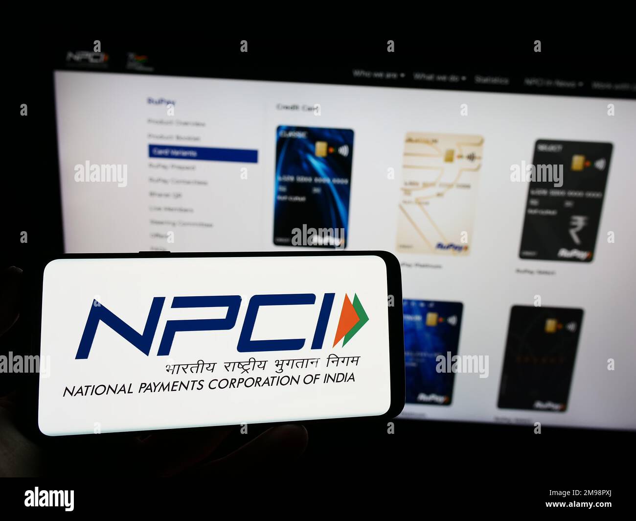 Person holding mobile phone with logo of National Payments Corporation of India (NPCI) on screen ...
